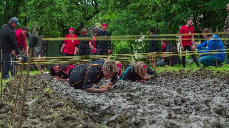 People Crawling through Mud As Part of Obstacle Course Stock Footage ...