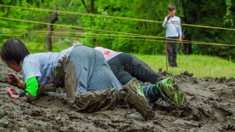 People Crawling through Mud As Part of Obstacle Course Stock Footage ...