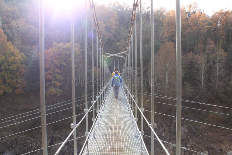 People Crossing a Footbridge Over a Canyon in the Middle Stock Image ...