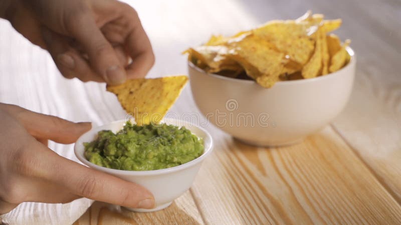 People Dipping Corn Chips into Guacamole Dip Stock Footage - Video of ...