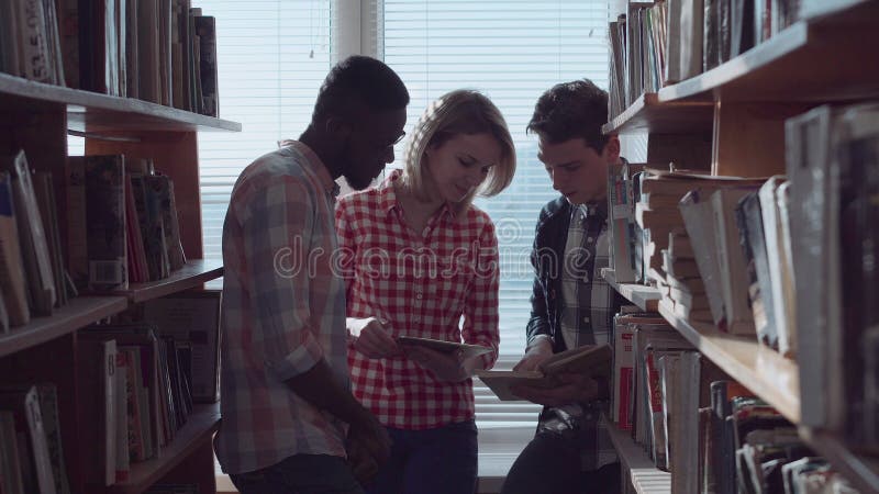 People Discussing Books between Stacks Stock Photo - Image of indoors ...