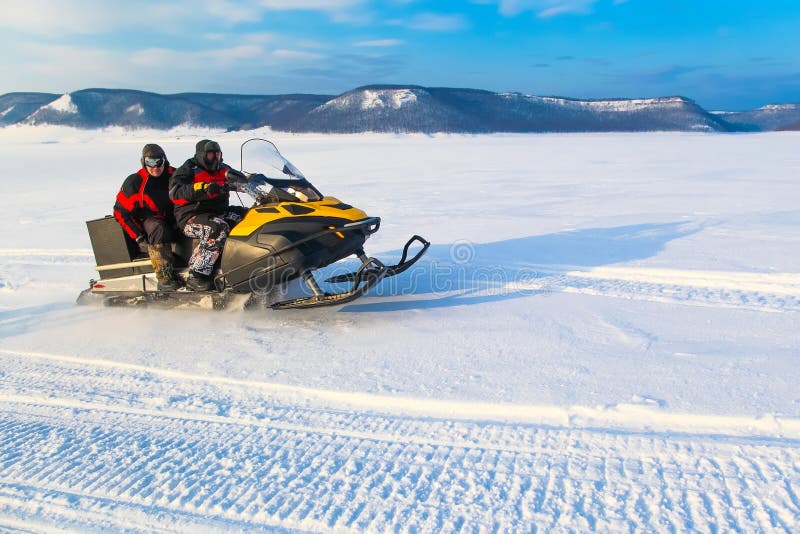 Man Driving A Snowmobile On A Background Of The Vast Expanses Of ...