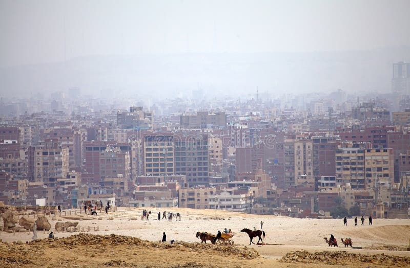 People at the Giza Pyramid Complex with Giza Town in the Background ...