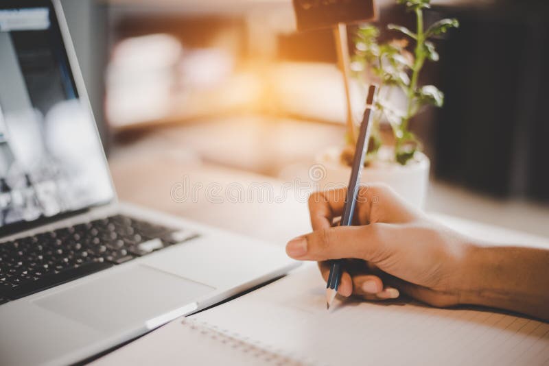 People Hand Using Pencil To Draw and Noting on Notepad. Laptop Computer ...