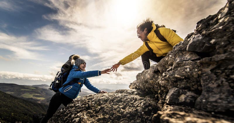 People Helping Each Other Hike Up a Mountain at Sunrise Stock Photo ...