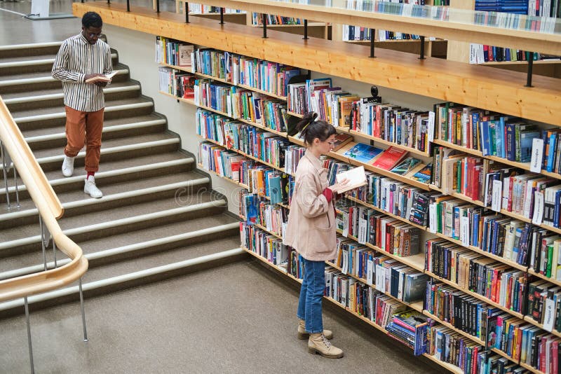 People in the library stock image. Image of shelf, holding - 220265703