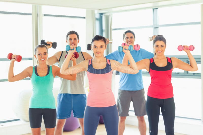 People Lifting Dumbbell Weights with Trainer in Gym Stock Image - Image ...