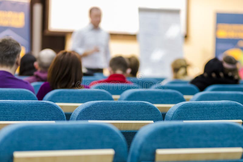 People Listening To Presenter in Front of a Group of Listeneres ...