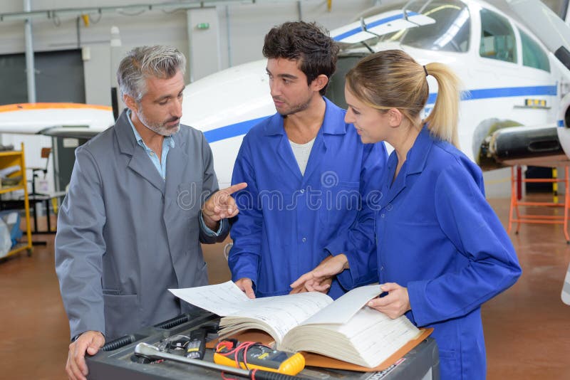 People Looking at Book in Aircraft Hangar Stock Photo - Image of force ...