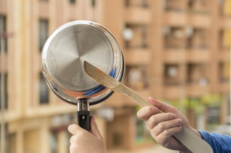People Make Noise by Hitting the Pot with a Wooden Spoon Stock Image ...