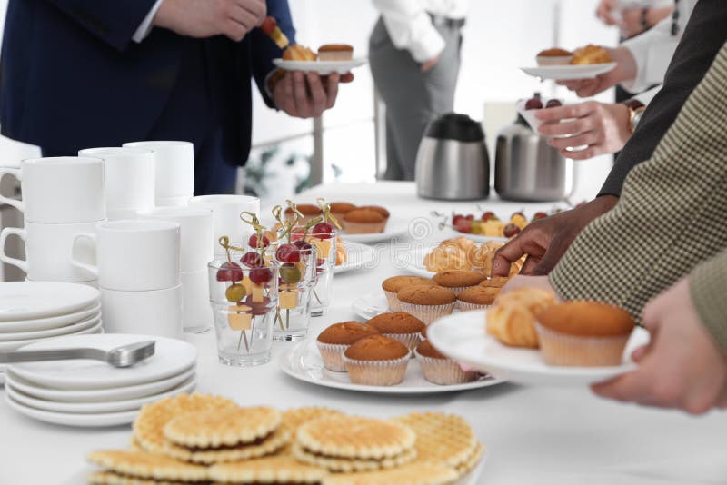 People Near Table with Different Delicious Snacks during Coffee Break ...