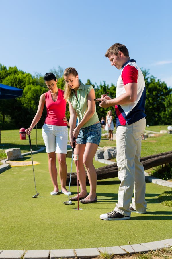 People Playing Miniature Golf Outdoors Stock Image - Image of putter ...