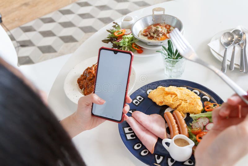 People Playing Smartphone while Eating Breakfast. White Space for Add ...
