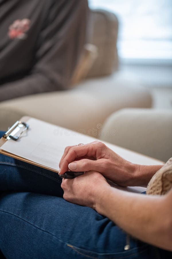 People in a Professional Therapy Session, the Therapist Taking Notes As ... People in a Professional Therapy Session, the Therapist Taking Notes As ...