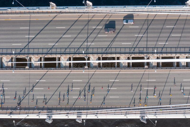 People Run Across the Bridge, the Shadows on the Asphalt Roads are ...