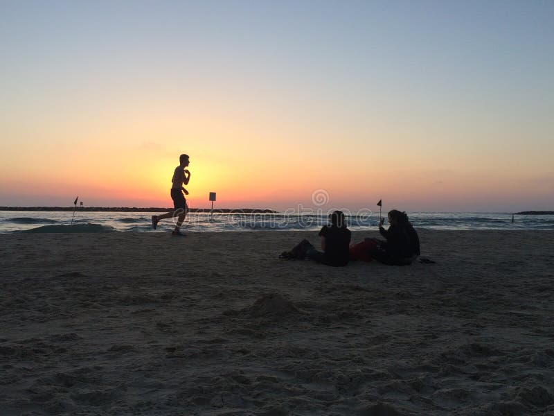 People run on the beach stock photo. Image of sunset - 56598016