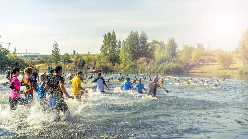 People running into a lake editorial stock image. Image of sunshine ...