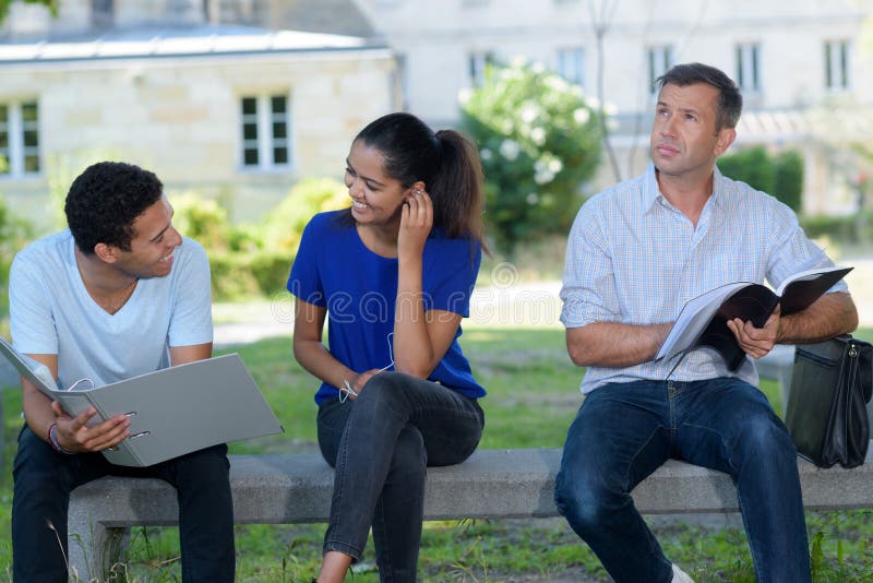 People Sat On Bench In University Campus Stock Photo - Image of ...