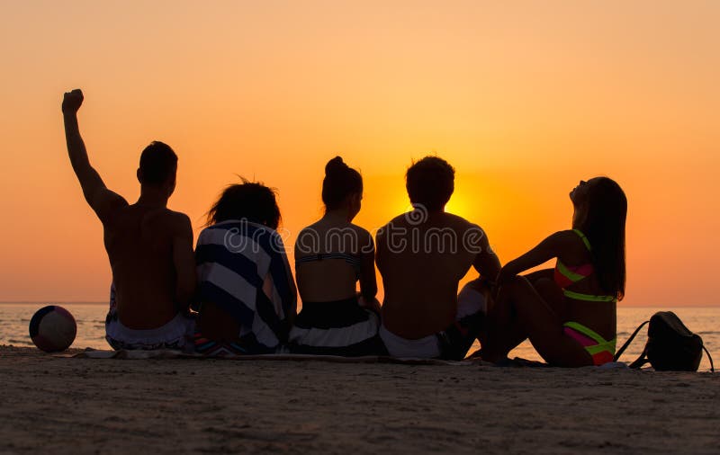 People Sitting on a Beach Looking at Sunset Stock Photo - Image of ...
