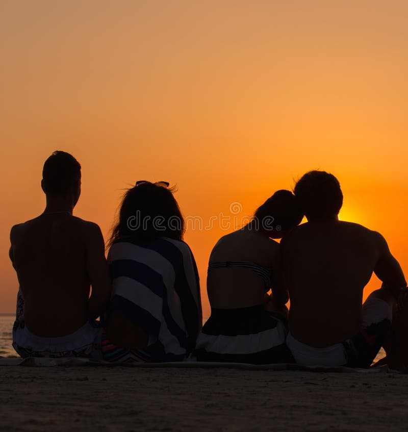 People Sitting on a Beach Looking at Sunset Stock Photo - Image of ...