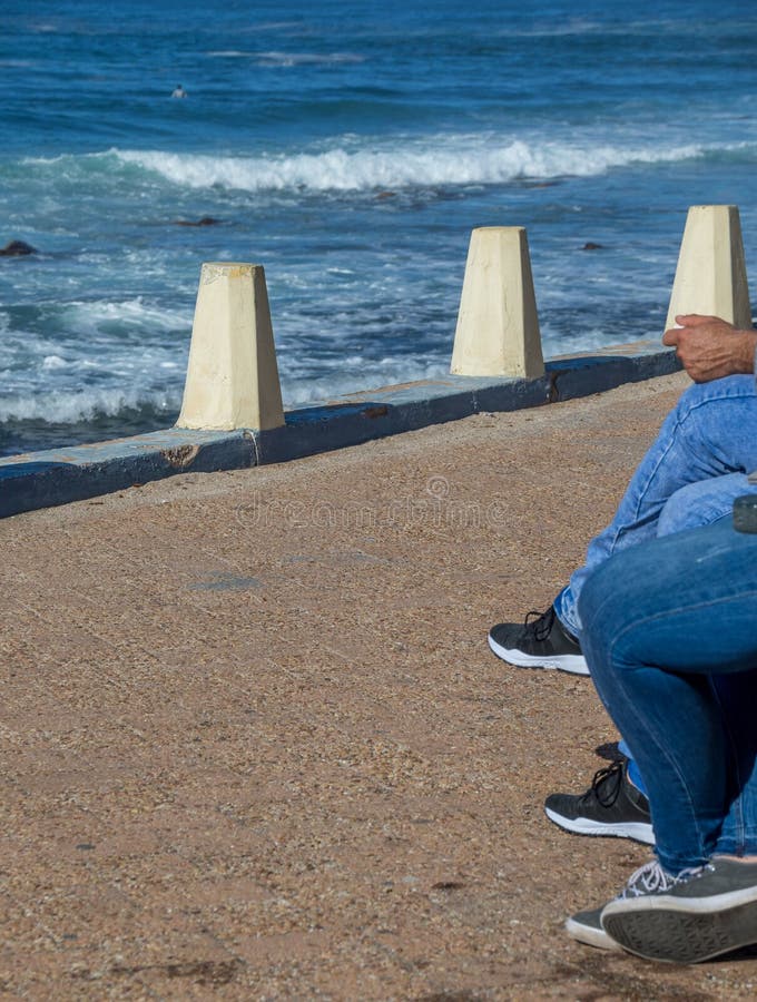 People Sitting Next To the Beachfront Overlooking the Sea Stock Photo ...