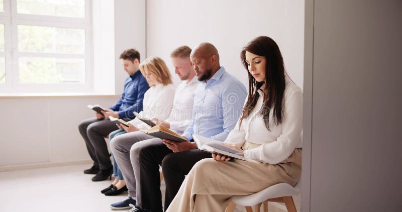 People Sitting in a Row Reading Stock Photo - Image of floor, people ...