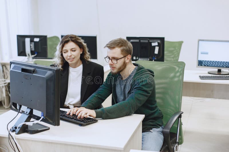 People Sitting at a Table in a Computer Room. Stock Image - Image of ...