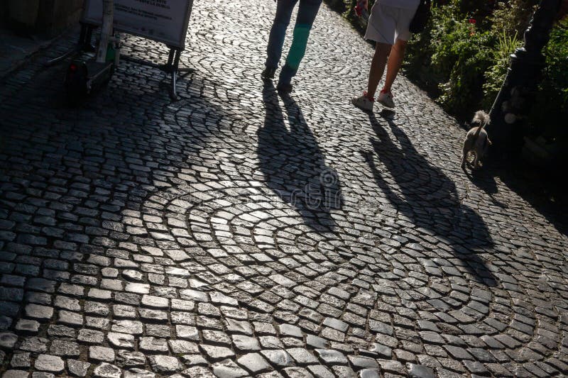 Walking Along a Cobblestone Path during the Evening, Shadows Stretch ...