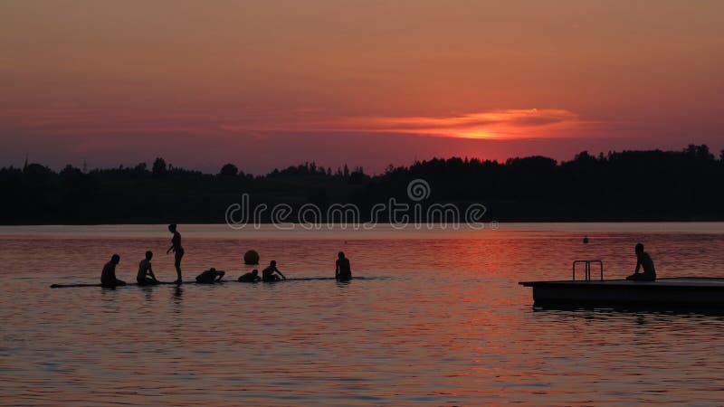People swimming at sunset stock photo. Image of cloud - 51763768