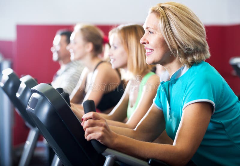 People Training on Exercise Bikes Together Stock Photo - Image of ...