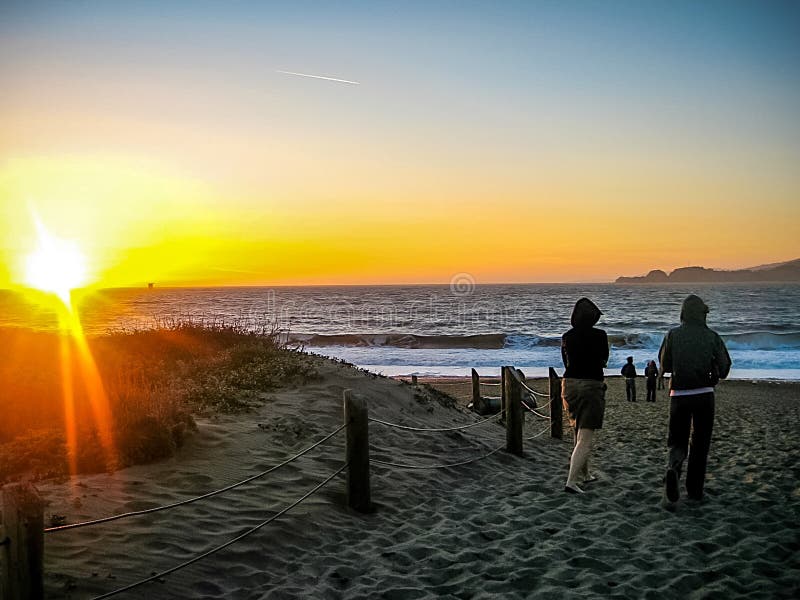 People Walking on Beach at Sunset Stock Photo - Image of gate, nature ...
