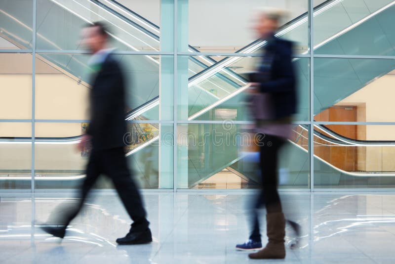 People Walking Quickly Down Hall in Office Building Stock Image - Image ...