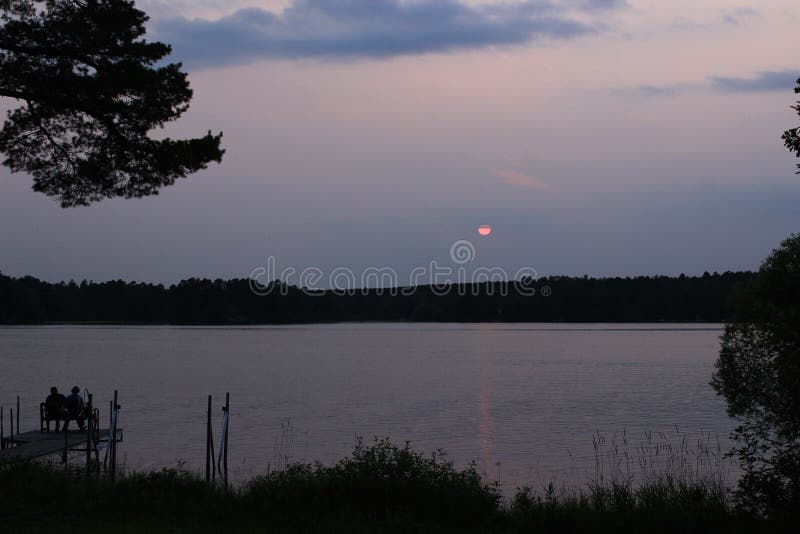 People Watching Sunset Over Lake Stock Photo - Image of lake, people ...