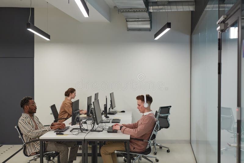 People Working at Computer Desks in Office Stock Photo - Image of code ...
