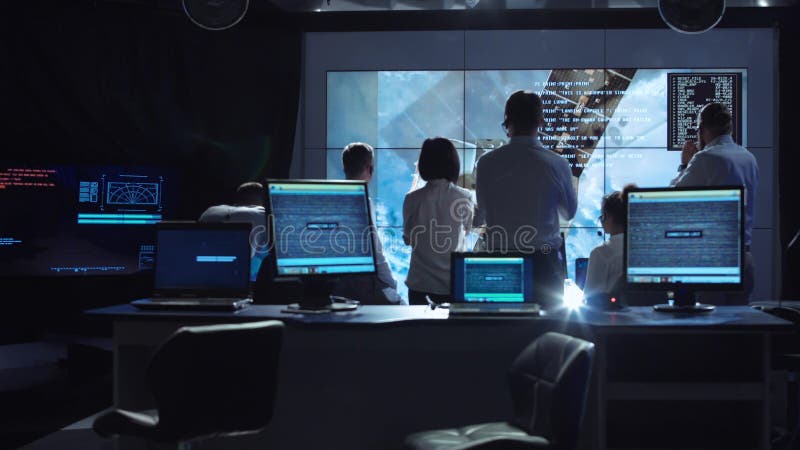 A Mission Control Room Full of Computer Monitors and People Watching ...