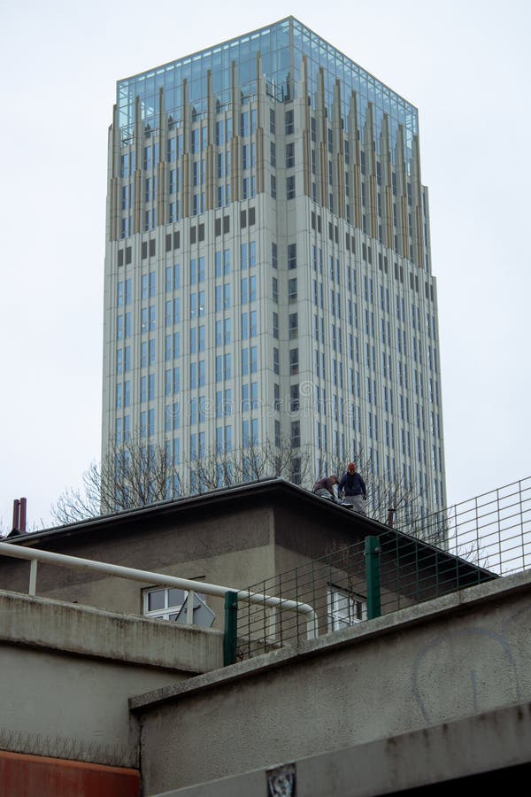 People Working on a Rooftop Towered by a Tall Building Stock Photo ...