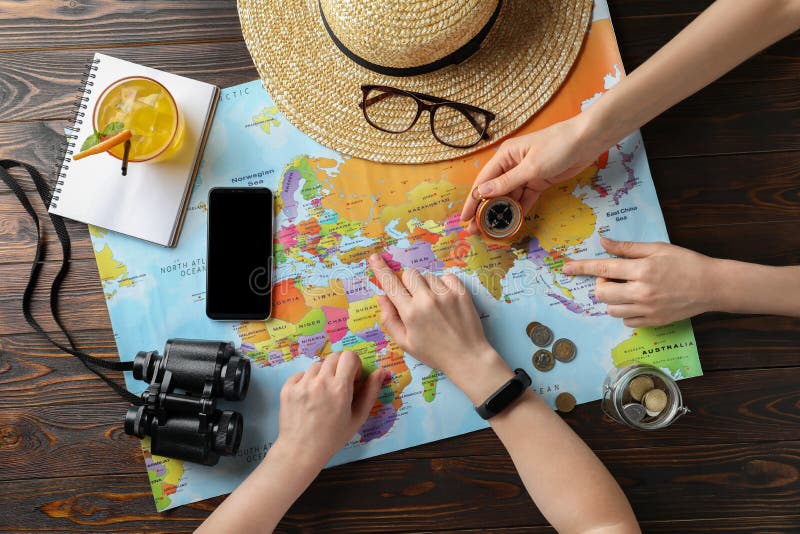 People with World Map and Accessories at Table, Top View. Travel during ...