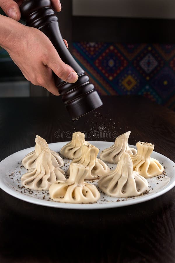 Peppering Khinkali. Pepper Sprinkled on Khinkali Stock Photo - Image of ...