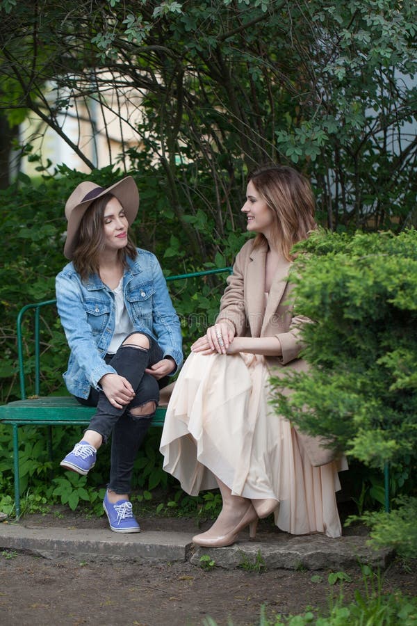 Perfect Friends Talking and Sitting on a Park Bench Outdoors Stock ...