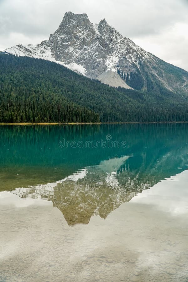 Perfect Reflection of Sharp Mountain Peaks and Forest in the Blue Water ...