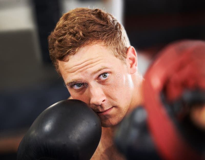 Perfecting His Punch. a Young Boxer Throwing a Punch at His Partners ... Perfecting His Punch. a Young Boxer Throwing a Punch at His Partners ...