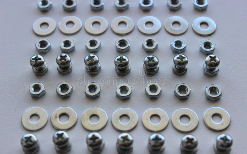 Perfectly Even Rows of Steel Shiny Nuts, Bolts and Washers on a White ...