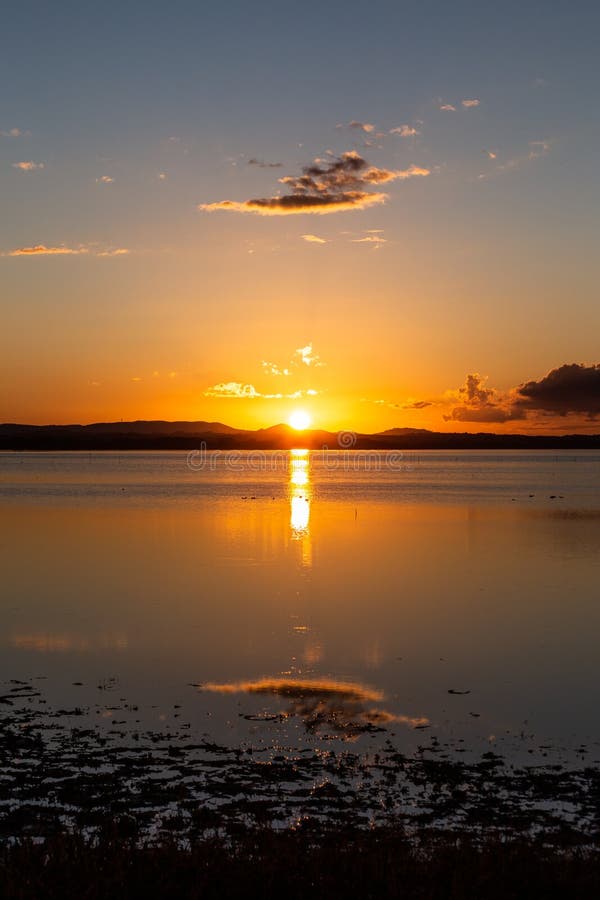 Perfectly Symmetric Clouds and and Sun Reflections on a Lake at Sunset Stock Photo - Image of ...