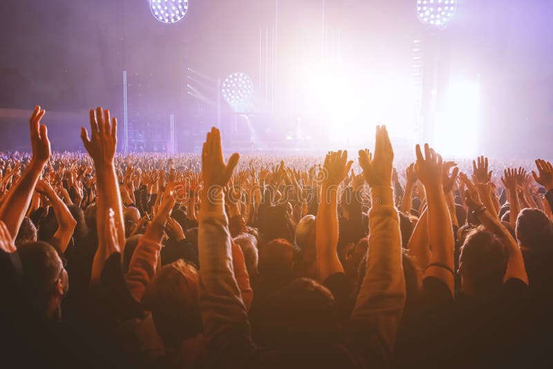 Performance of a Popular Group. the Crowd with Raised Hands Against the ...