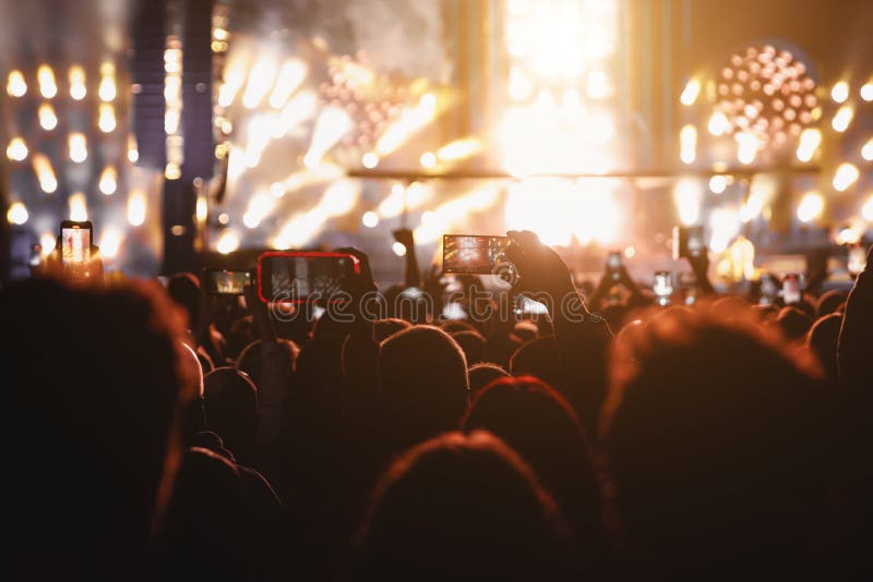 Performance of a Popular Group. the Crowd with Raised Hands Against the ...