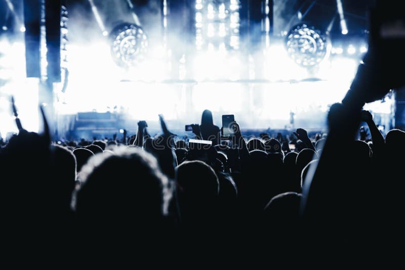 Performance of a Popular Group. the Crowd with Raised Hands Against the ...