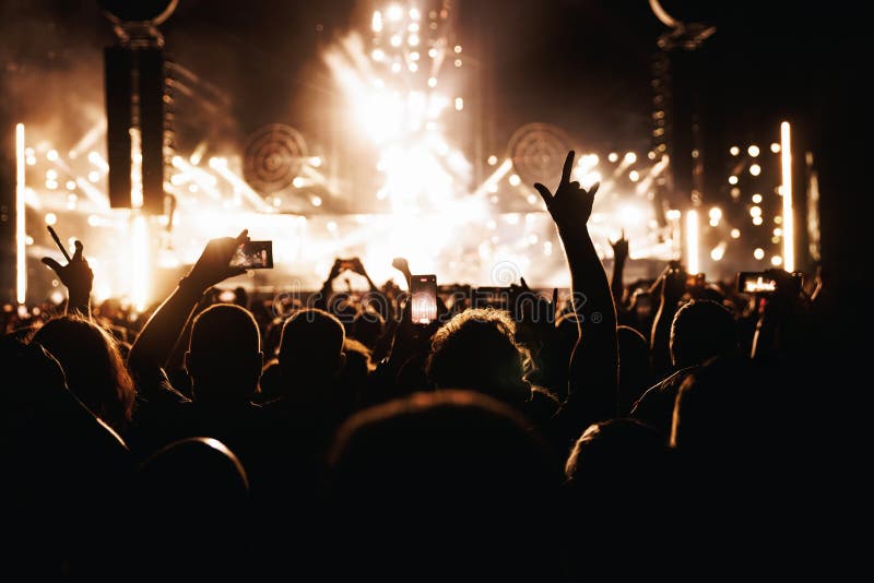 Performance of a Popular Group. the Crowd with Raised Hands Against the ...