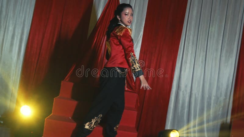 Confident Female Performer in Red Costume on Stage with Dramatic ...