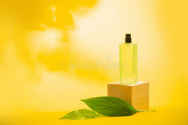 Perfume Bottle with Green Leaves on Yellow Background Stock Image ...