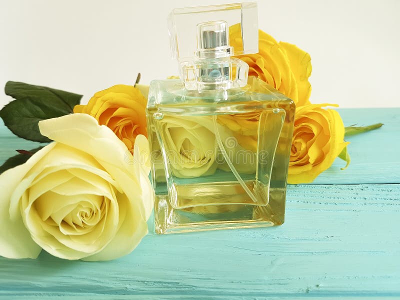 Perfume Bottle with Yellow Roses on a Wooden Stock Photo - Image of ...